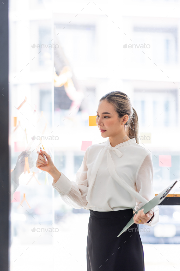 Young Asian woman Creative team use post it notes to share idea sticky ...