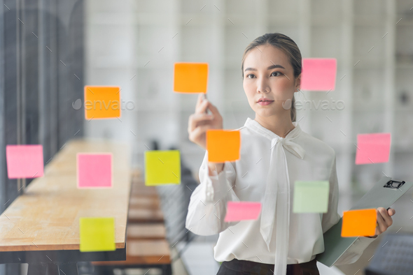 Young Asian woman Creative team use post it notes to share idea sticky ...