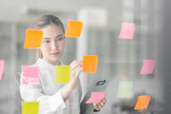 Young Asian woman Creative team use post it notes to share idea sticky ...