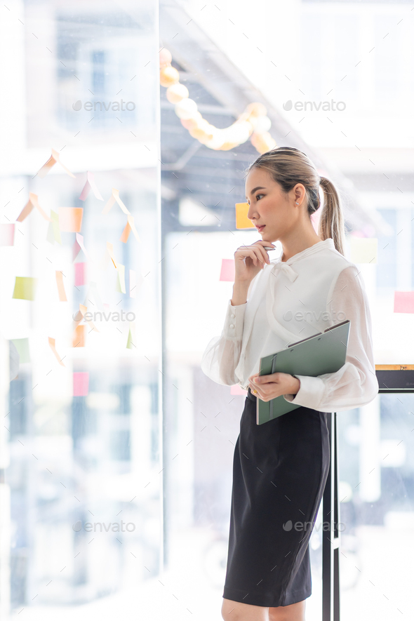 Young Asian woman Creative team use post it notes to share idea sticky ...