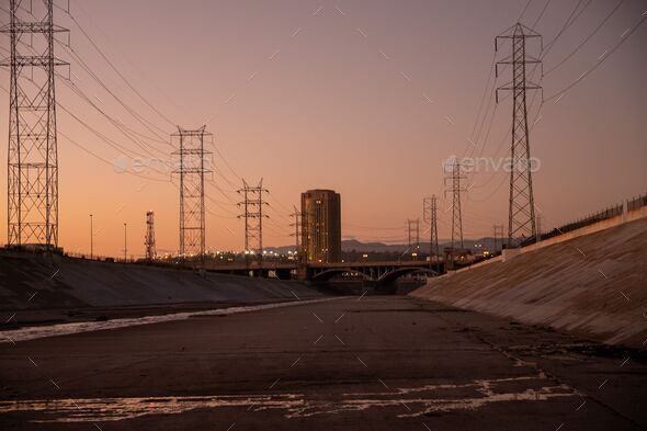Bright sunset sky over flat land with electricity towers in downtown ...
