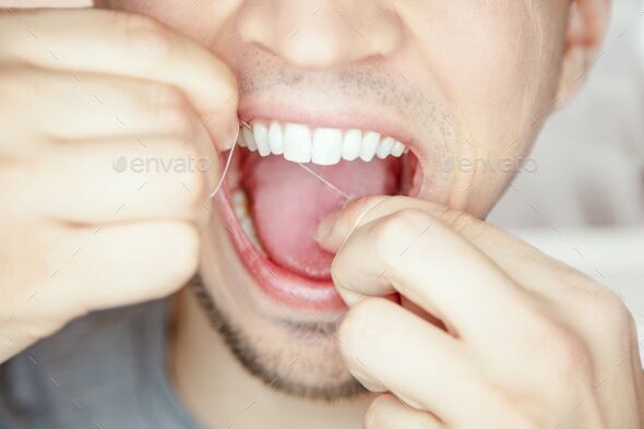 Male hand cleaning and dislodging food stuck between teeth Stock Photo ...