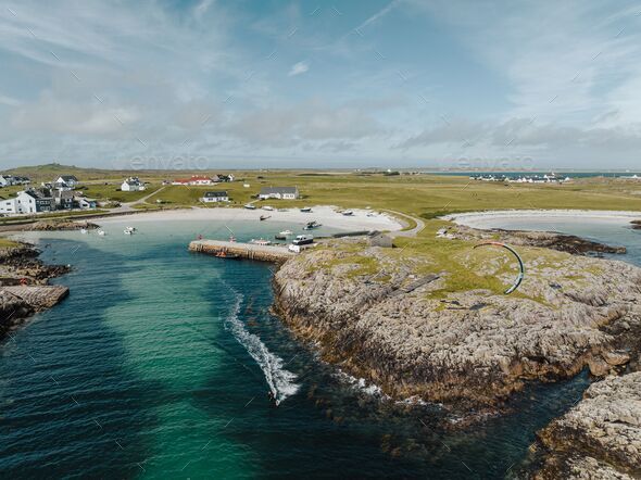 Aerial view of a sandy beach along Tiree island in Scotland with houses ...