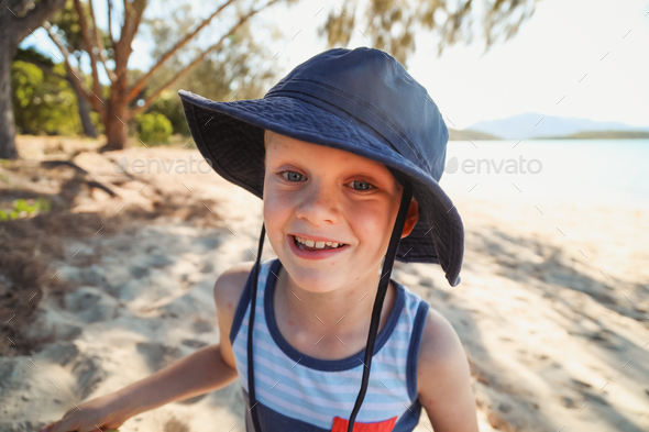 Portrait of an Australian little boy wearing a hat excited looking at ...