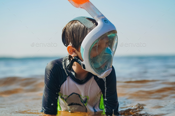 cute little caucasian boy wearing snorkeling maskswimming in the sea ...