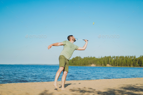 caucasian man playing badminton on the lakeside. Image with selective ...
