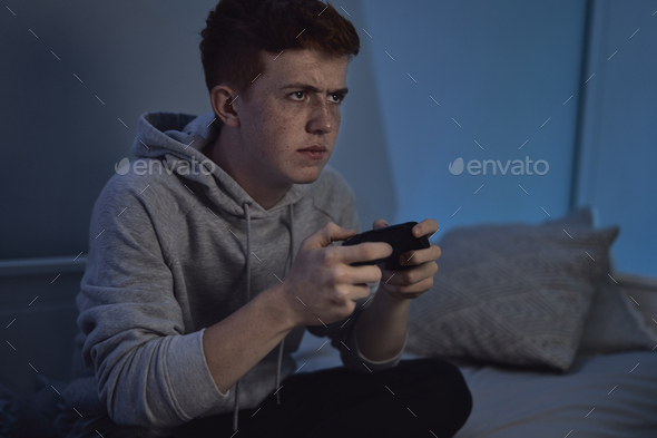Caucasian teenage boy playing on game controller at night Stock Photo ...
