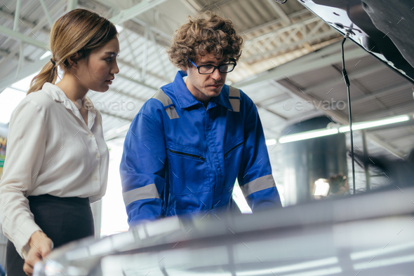 Repairman or car mechanic showing and explaining broken part to ...