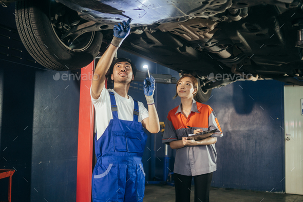 Asian repairman or car mechanic showing and explaining vehicle broken ...