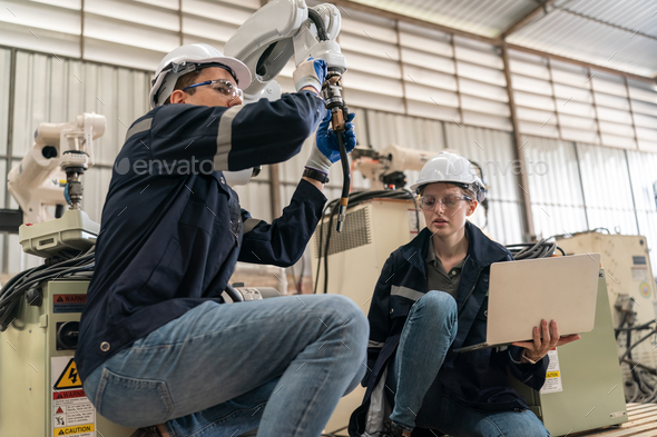 Industrial factory employee working on High Tech Robotic Arm with an ...
