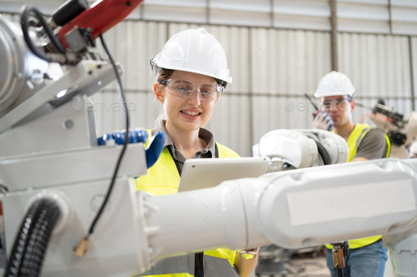 Industrial factory employee working on High Tech Robotic Arm with an ...