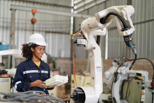 Industrial factory employee working on High Tech Robotic Arm with an Artificial Intelligence on ...