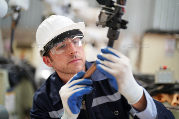 Industrial factory employee working on High Tech Robotic Arm with an ...
