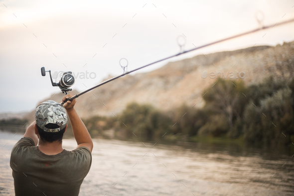 Back view of a male fishing in the river Stock Photo by wirestock ...
