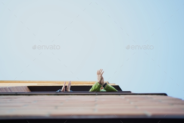 Low angle shot of an adult and young hands on the balcony of a house ...