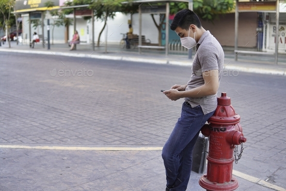 Shallow focus side profile shot of a male with a mask leaning on a fire ...