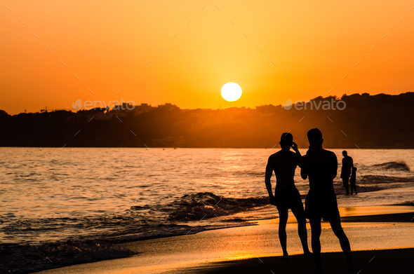 Crowded Praia de Nossa Senhora da Rocha beach with people silhouettes ...