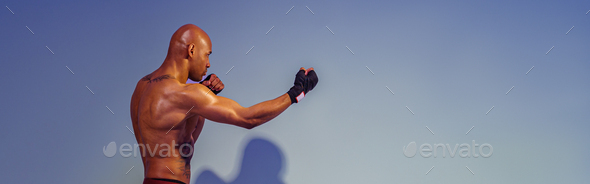 Professional kickboxer is training and practicing punch on studio ...