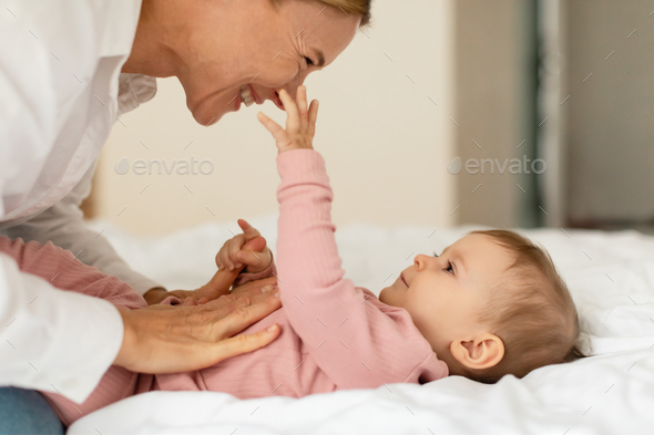 Loving mom playing with baby at home, enjoying motherhood and maternity ...