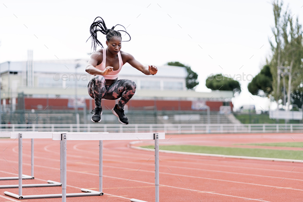 African-American athlete sprinter jumping a hurdle Stock Photo by ...