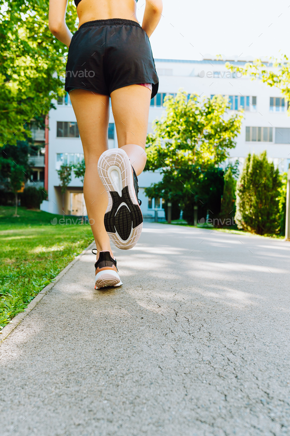 Legs of an athlete in running shoes on morning run Stock Photo by ...