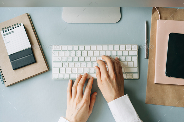 Elegant female hands typing on a computer keyboard, top view of a ...