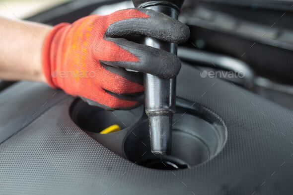 Car maintenance, service man changing motor oil in a modern passenger ...
