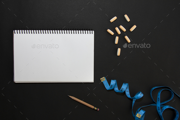 Closeup image of a horizontal notebook with a pencil and a blue ...