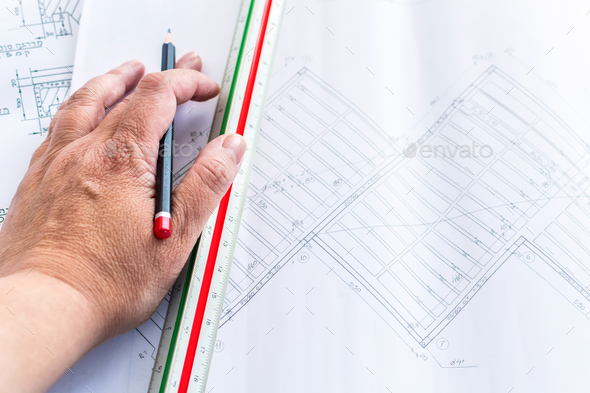 Close-up shot of an architect working on the blueprint at the desk ...