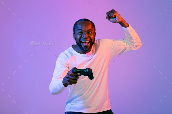 Joyful african american man playing video games with joystick Stock ...