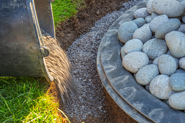 Closeup shot of gritting material being poured onto a garden fountain ...