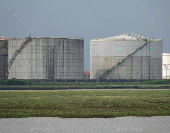Oil storage tanks outside under a gloomy sky in a refinery base Stock ...