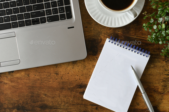 White unlined notebook & pen by laptop computer on desk workspace ...