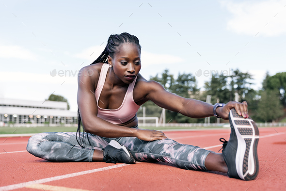 Athlete sprinter stretching her legs Stock Photo by nunezimage | PhotoDune