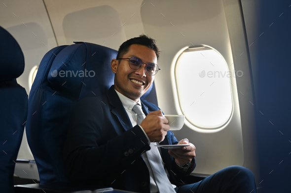 Positive businessman passenger drinking coffee from paper cup in ...