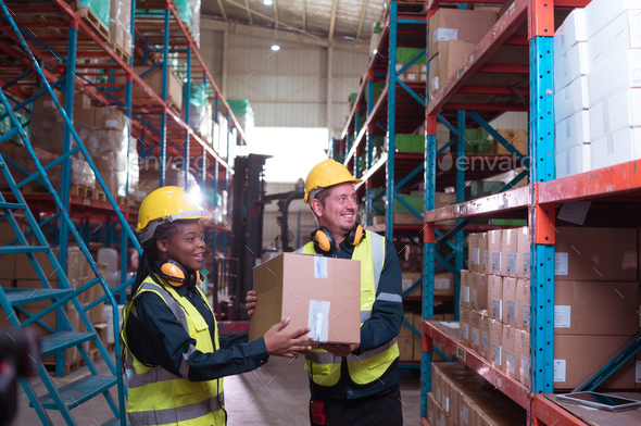 Foreman with employees in warehouse Help each other lift the product ...