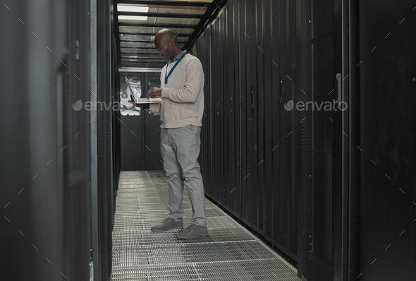 Server room, data center or IT black man with laptop for research ...