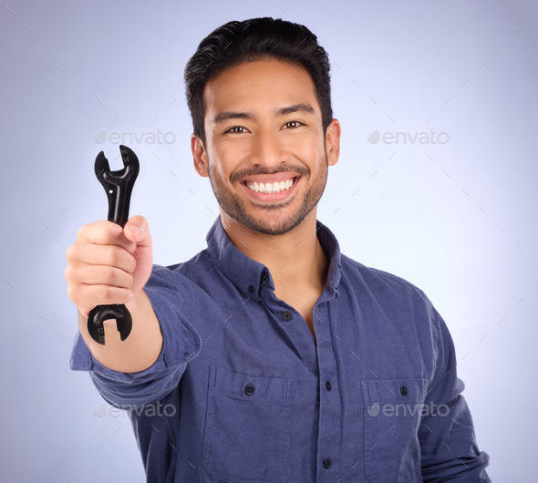 Portrait of man with wrench tool isolated on studio background for ...