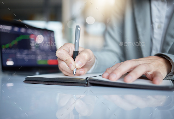 Trader, hands and writing notes by laptop in book on stock market chart ...