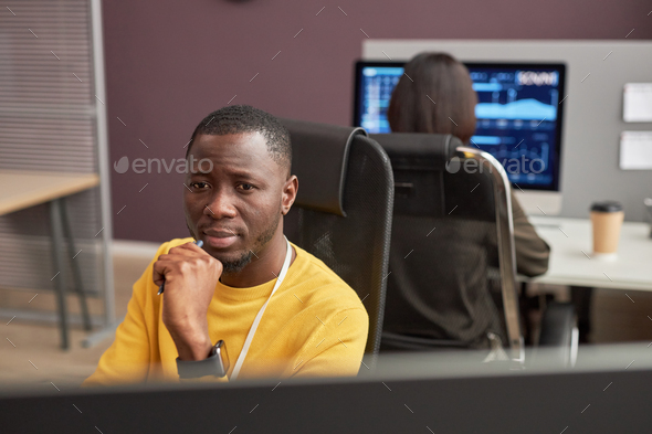 Focused black man looking at computer screen in office Stock Photo by ...