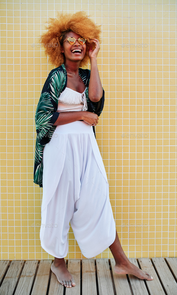 Barefoot African woman in summer clothes with heart-shaped sunglasses ...