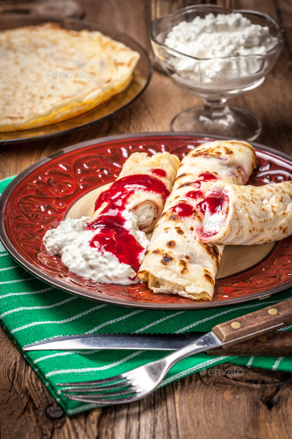 Rolled crepes stuffed with cottage cheese. Stock Photo by foto_pstryki
