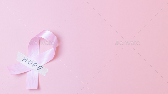 Pink ribbon with sticky tape and the word: hope on a pink background ...