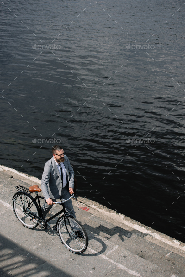 overhead view of businessman with bike walking on quay Stock Photo by ...