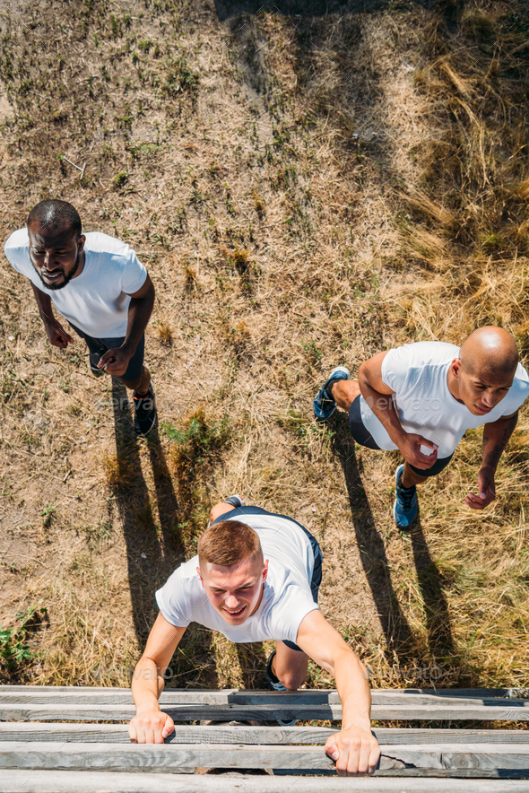 overhead view of multiethnic soldiers practicing in obstacle run on ...