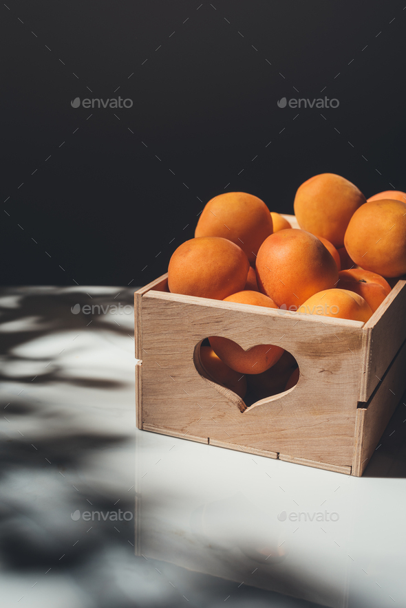 food composition with apricots in wooden box with heart shaped sign on ...