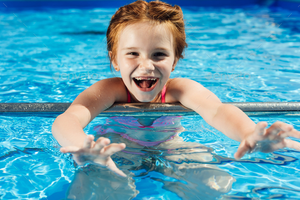 close-up portrait of adorable little child in bikini in swimming pool ...