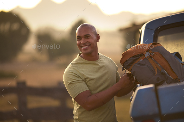 Man Loading Backpack Into Pick Up Truck For Road Trip To Cabin In ...