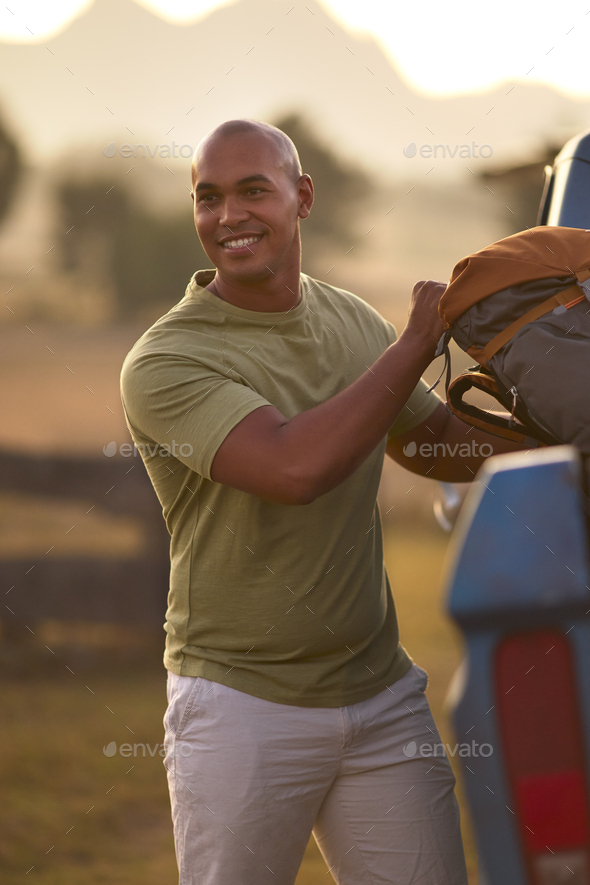 Man Loading Backpack Into Pick Up Truck For Road Trip To Cabin In ...