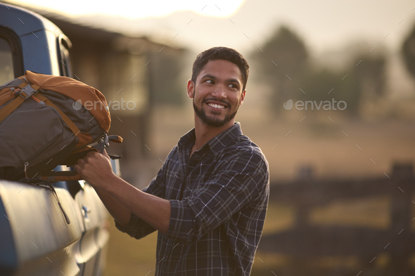 Man Loading Backpack Into Pick Up Truck For Road Trip To Cabin In ...